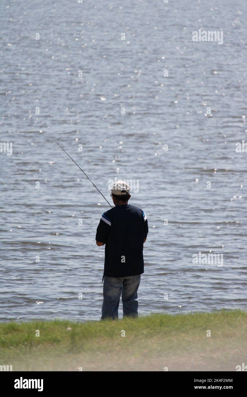 A rear view of a man with fishing rod Stock Photo - Alamy