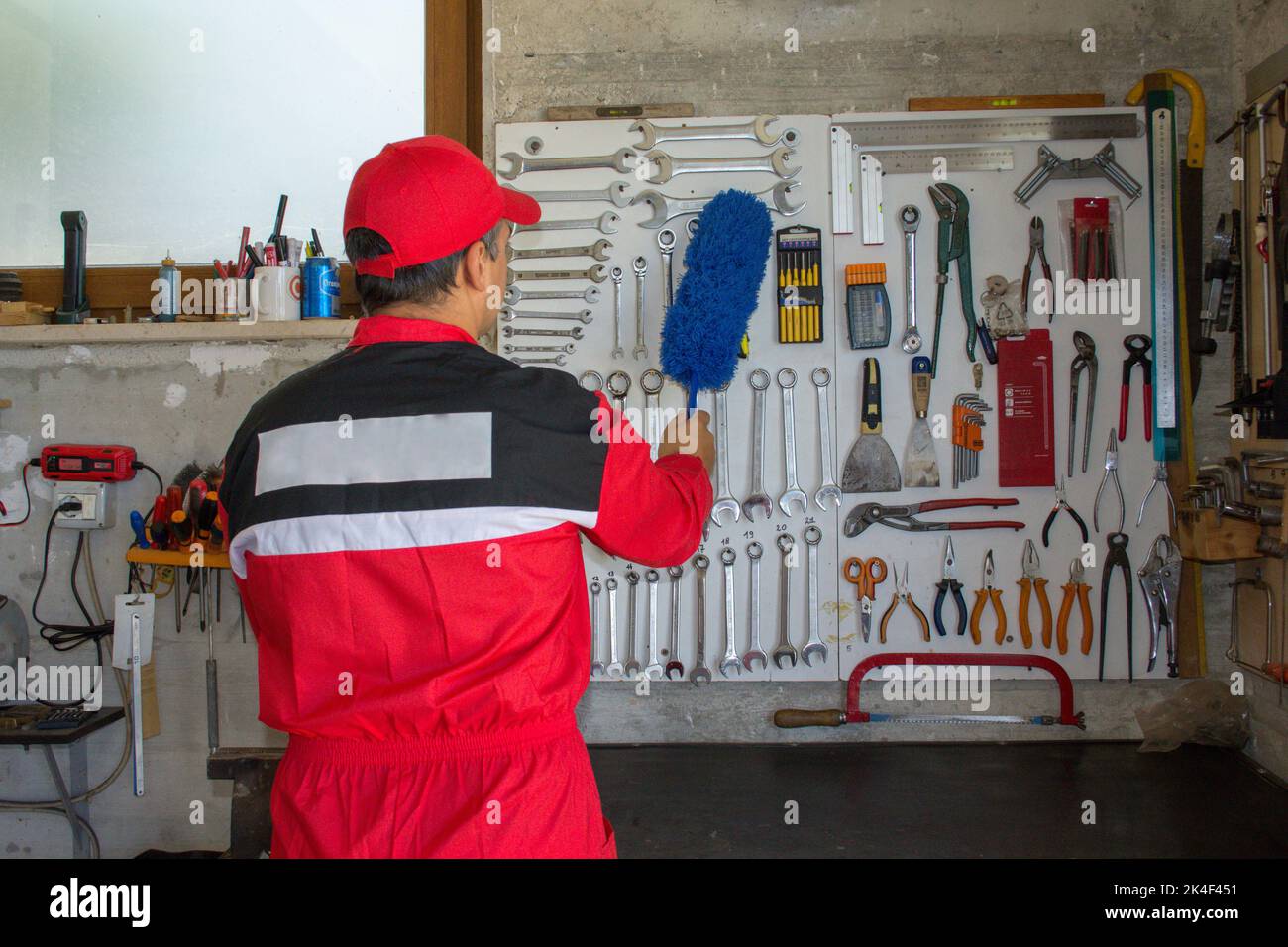 Picture of a mechanic cleaning tools in his workshop with a duster ...