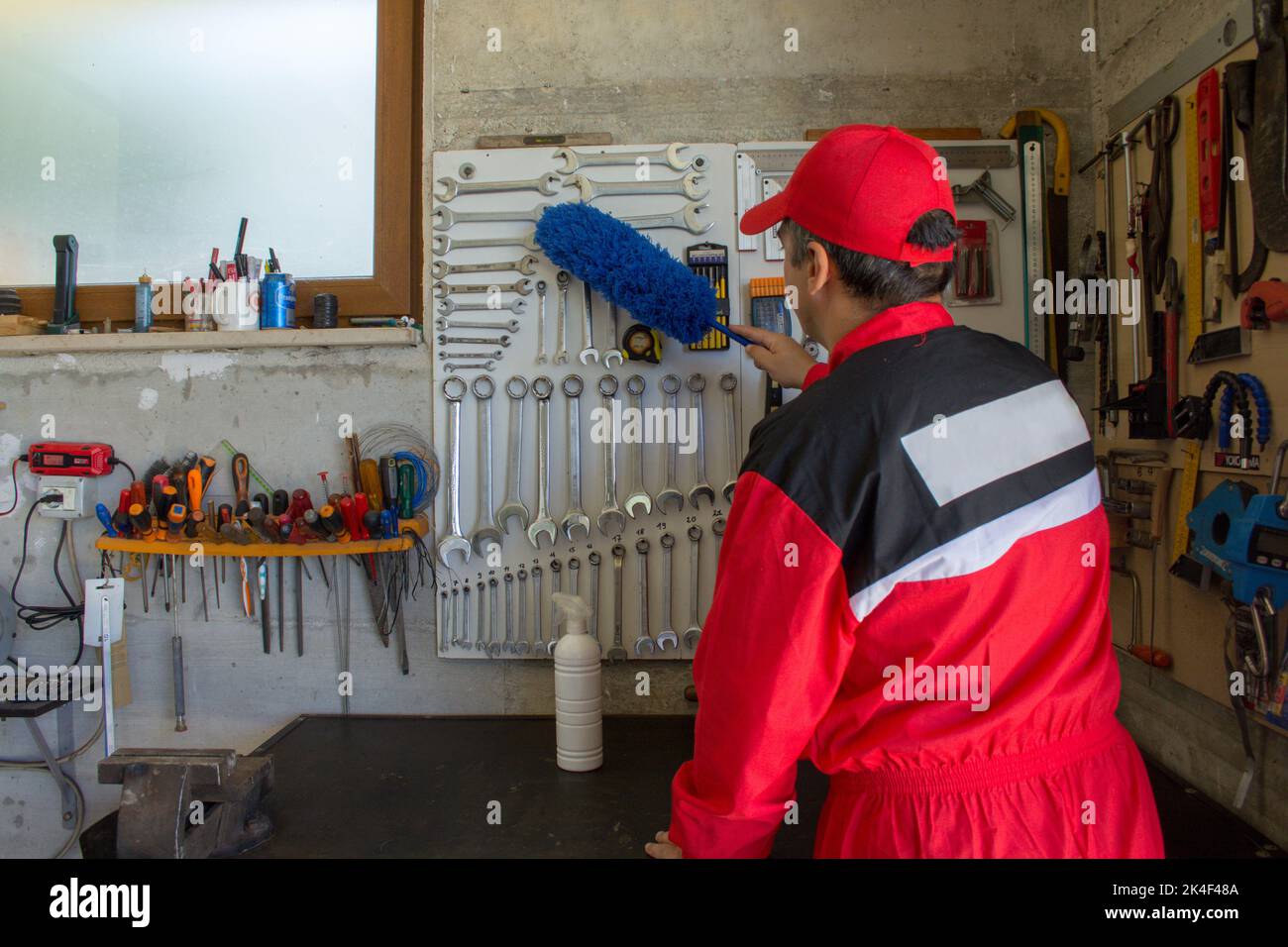 Picture of a mechanic cleaning tools in his workshop with a duster ...