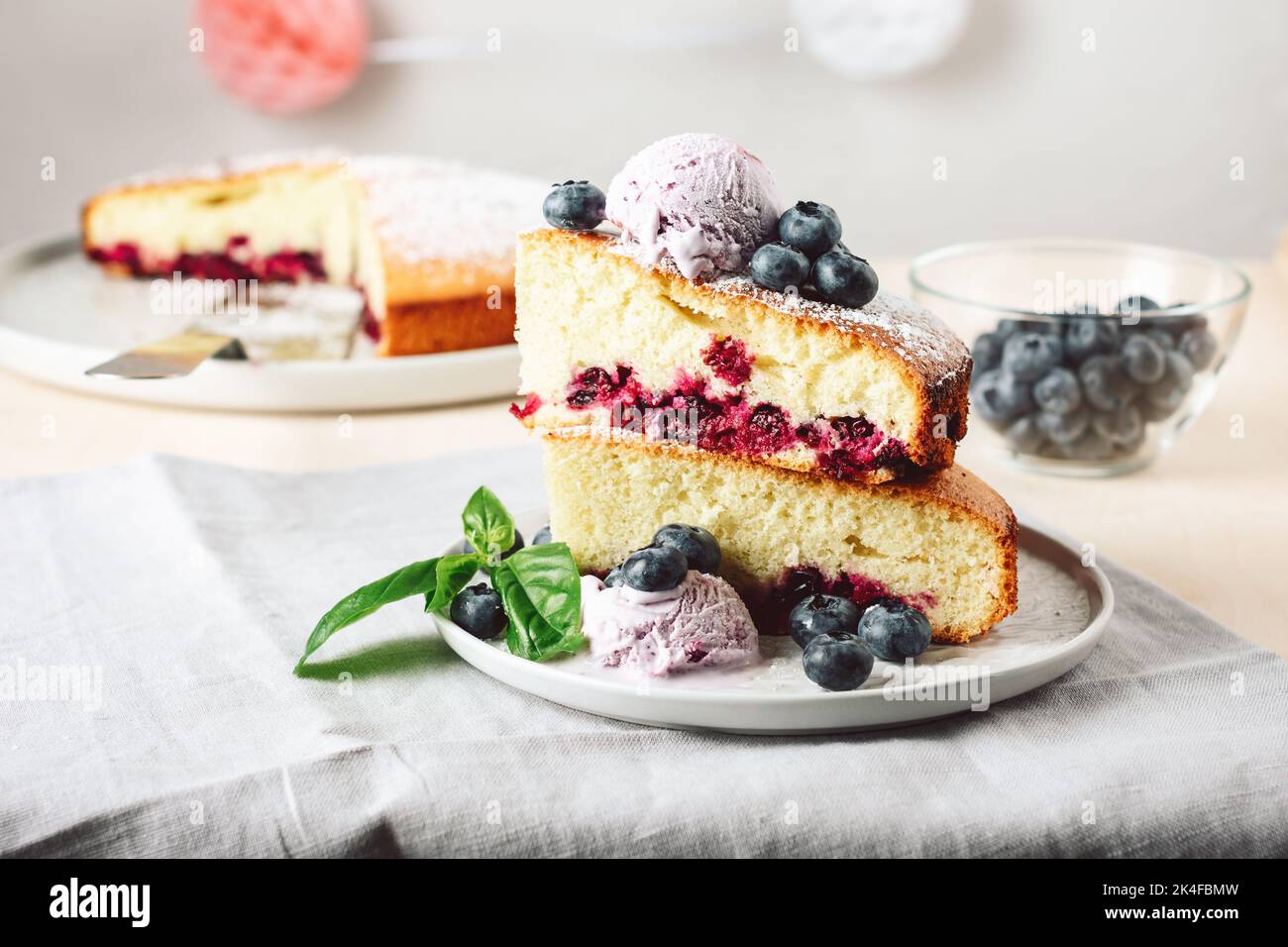 Two pieces of blueberry sponge cake with berry ice cream Stock Photo ...