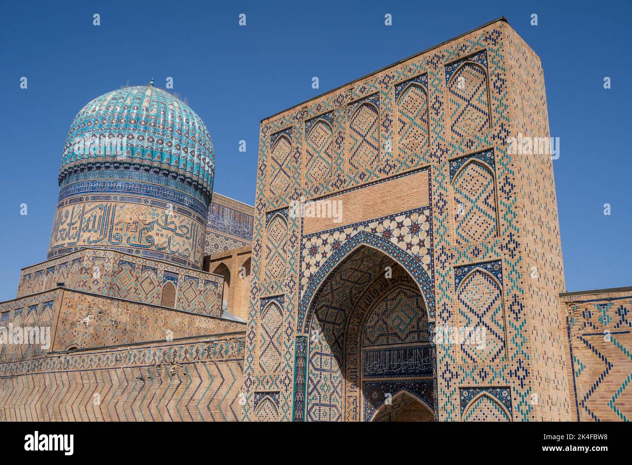 Blue tile dome and gate of Bibi-Khanym Mosque in bright blue sky in ...