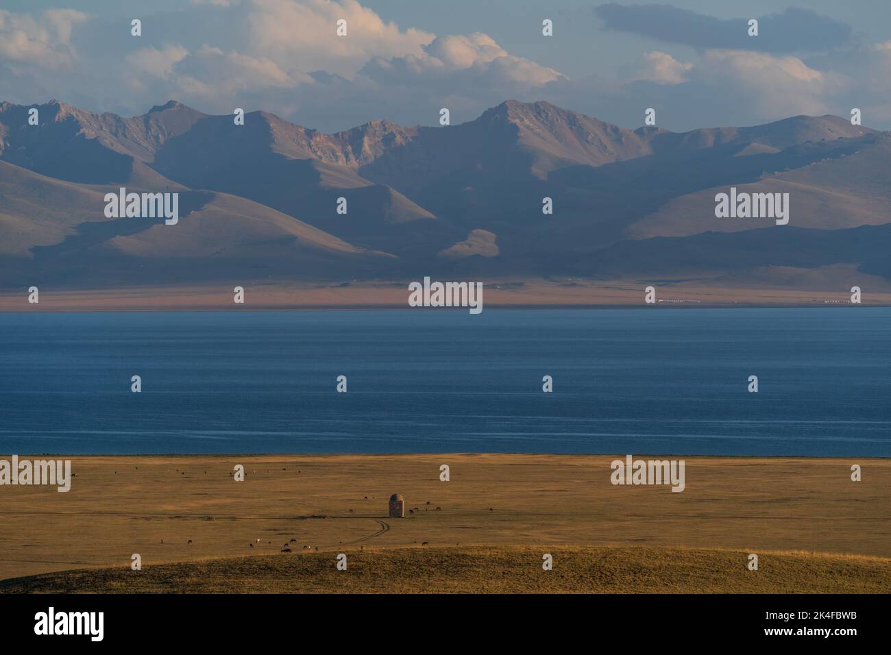 Shore and gentle rolling hills of Song Kul Lake during golden hour ...