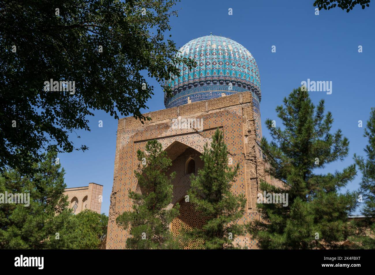 Blue tile dome and gate of Bibi-Khanym Mosque in bright blue sky in ...