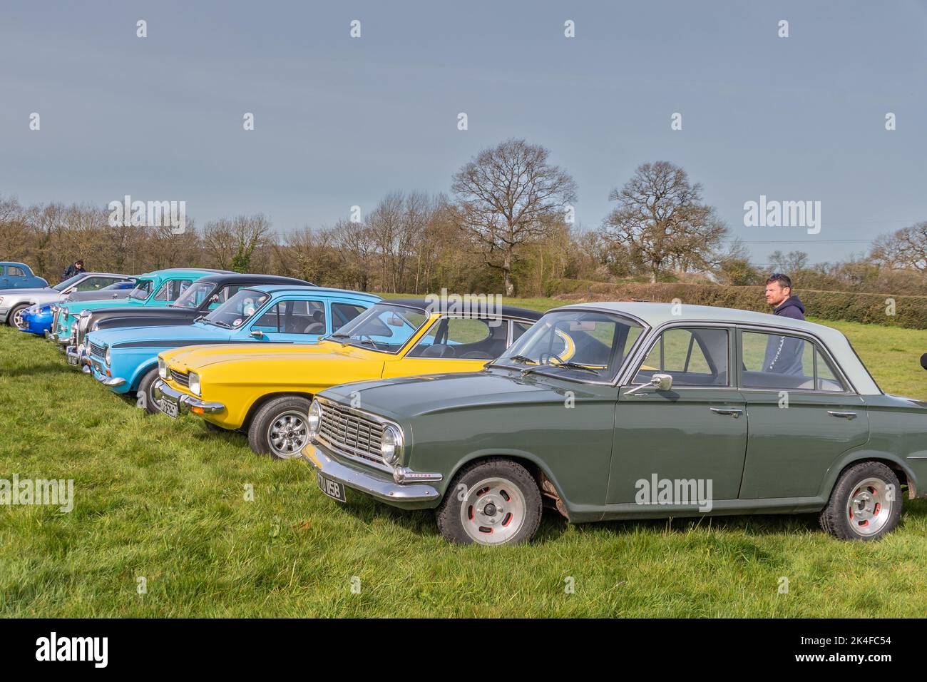 A row of classic cars from the British roads parked on grass at a ...