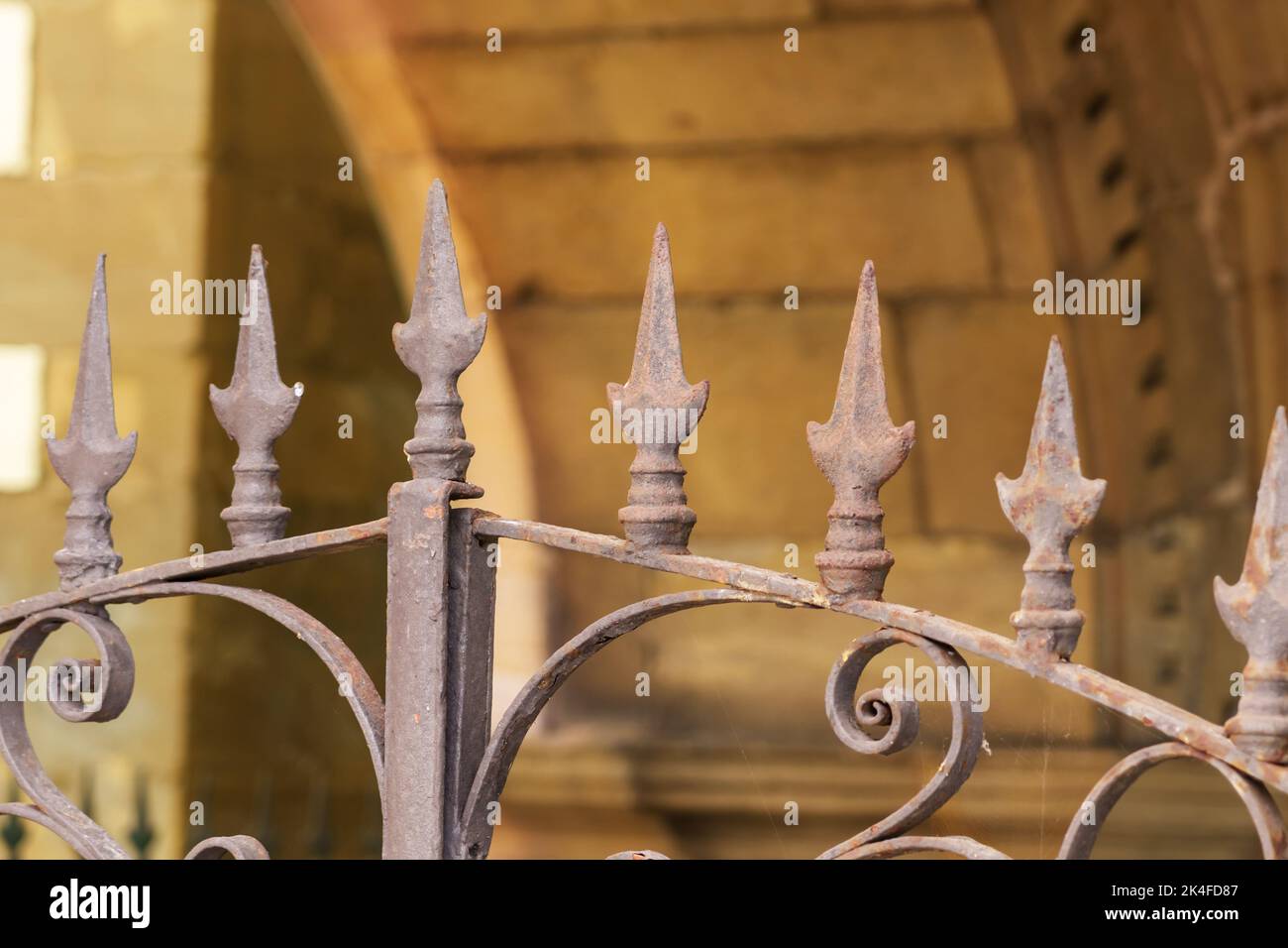 Rusty forged iron fence with spikes and peaks of an antique medieval ...