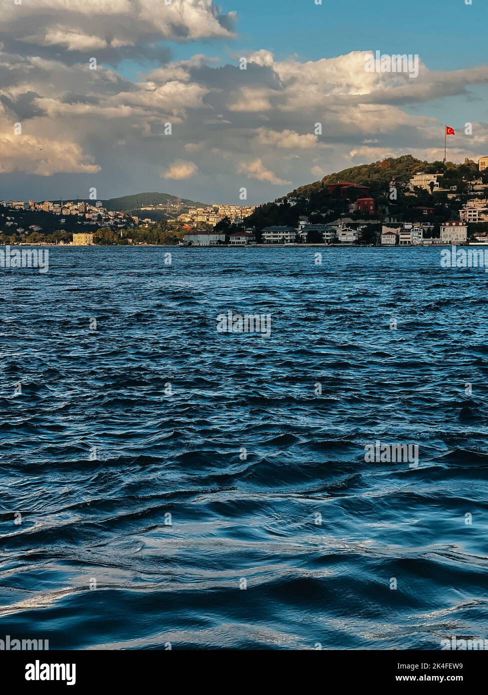 A vertical shot of a blue ocean along buildings in the city of Istanbul ...