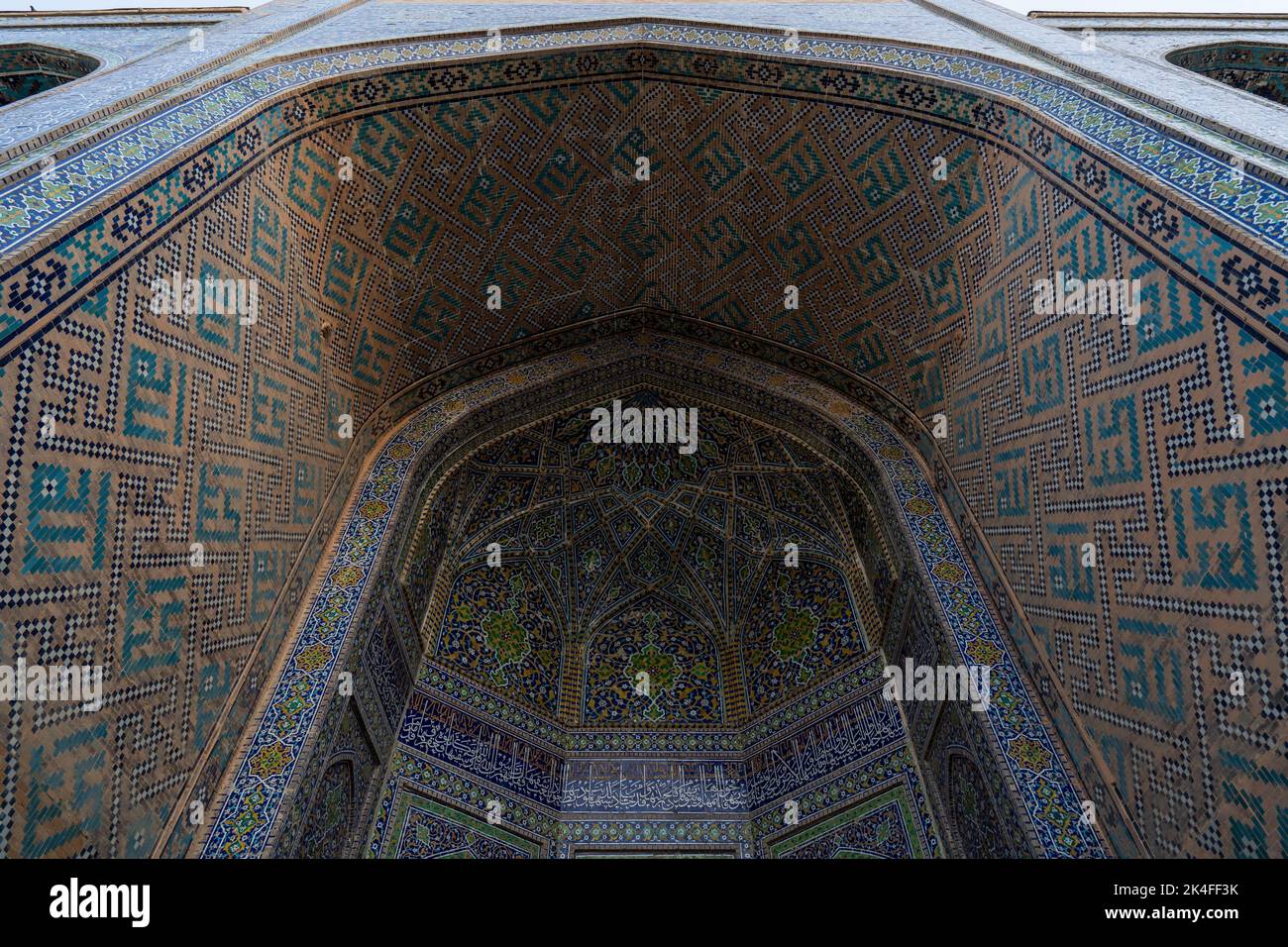 Registan intricate blue tile arch vault in courtyard at sunset ...