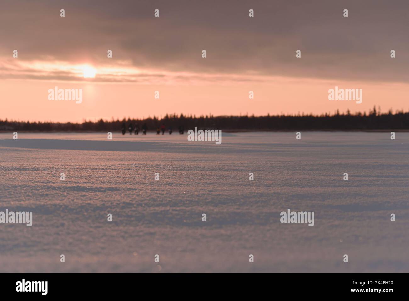Group of people walking through winter landscape on ice of frozen sea ...