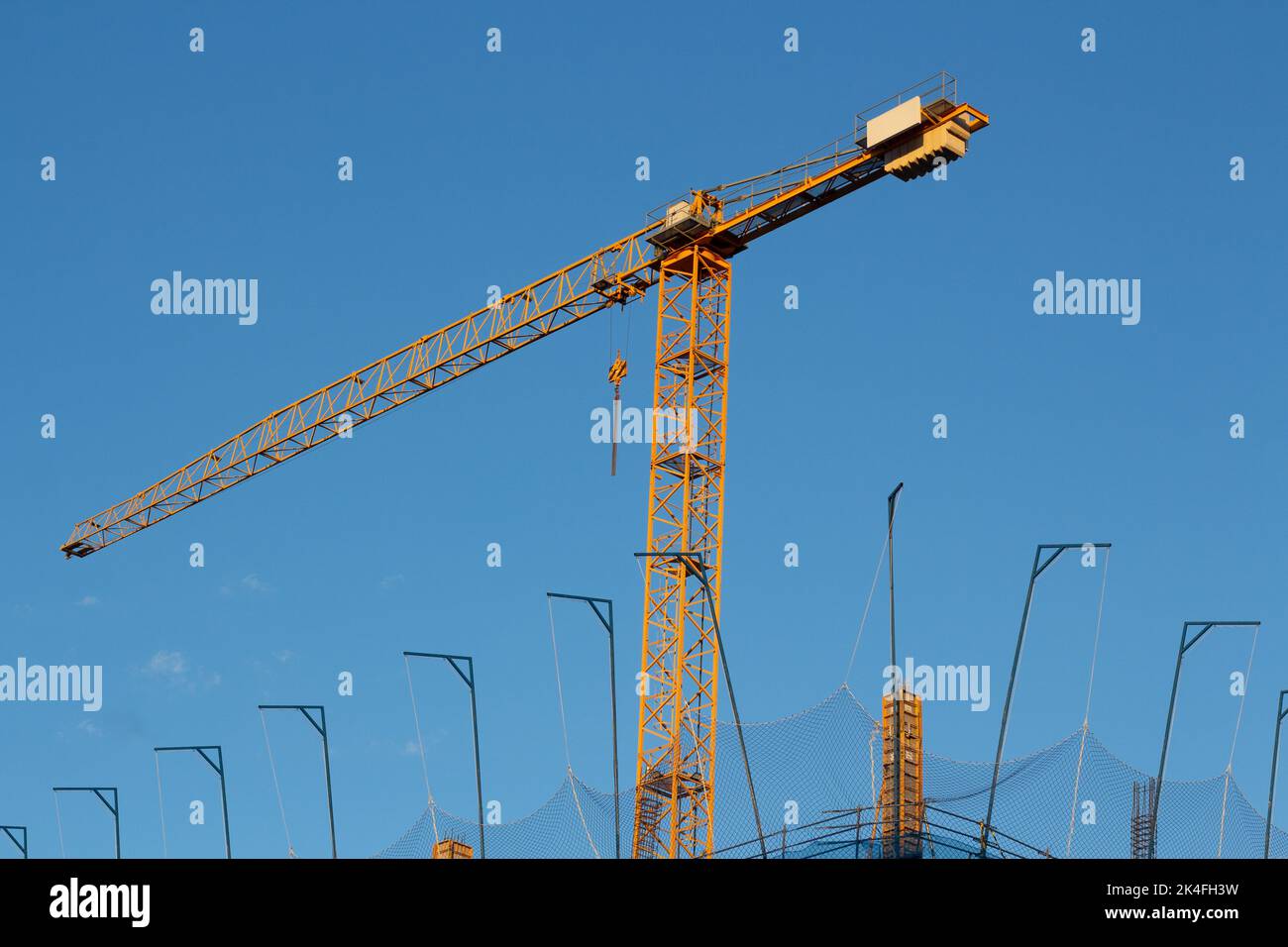 yellow construction crane on a deep blue background Stock Photo - Alamy