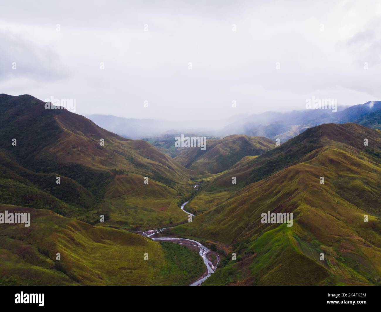 A landscape of a road through green hills in Bukidnon, Philippines ...
