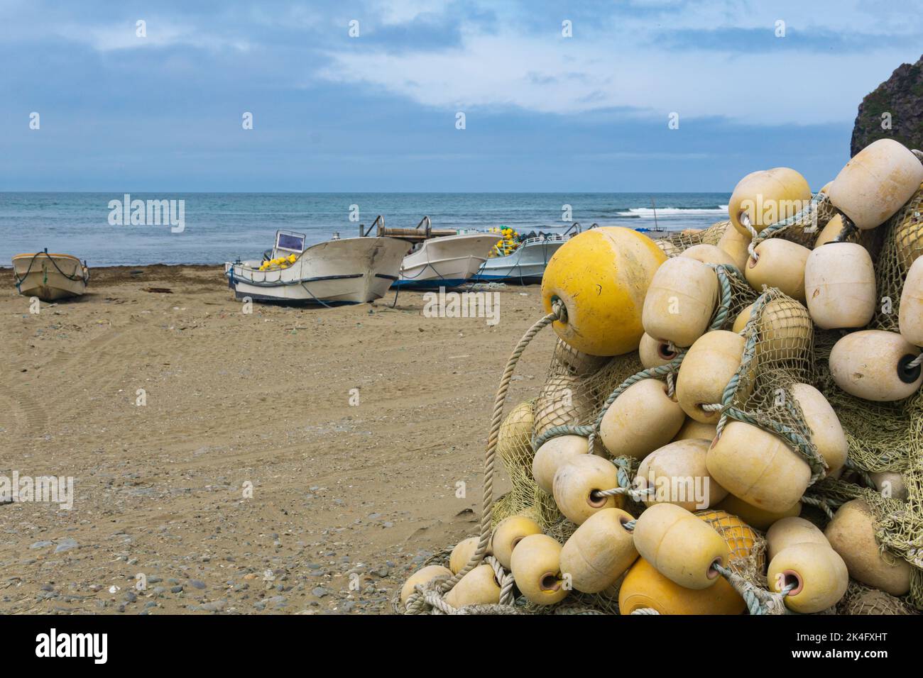 industrial fishing net with bright floats is folded on the seashore ...