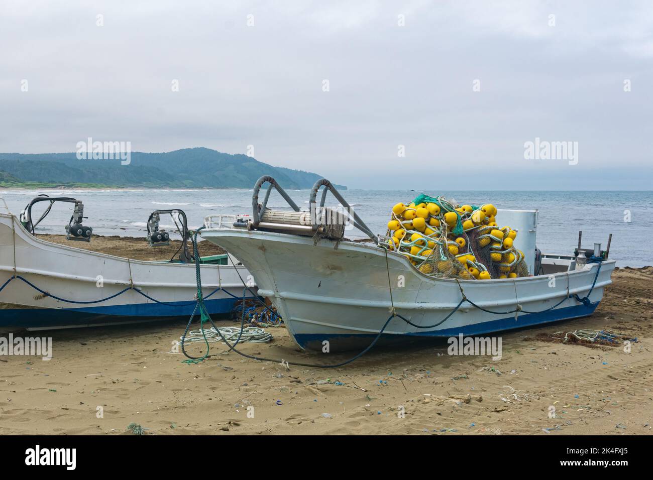 small fishing boats with a net on board on the seashore Stock Photo - Alamy