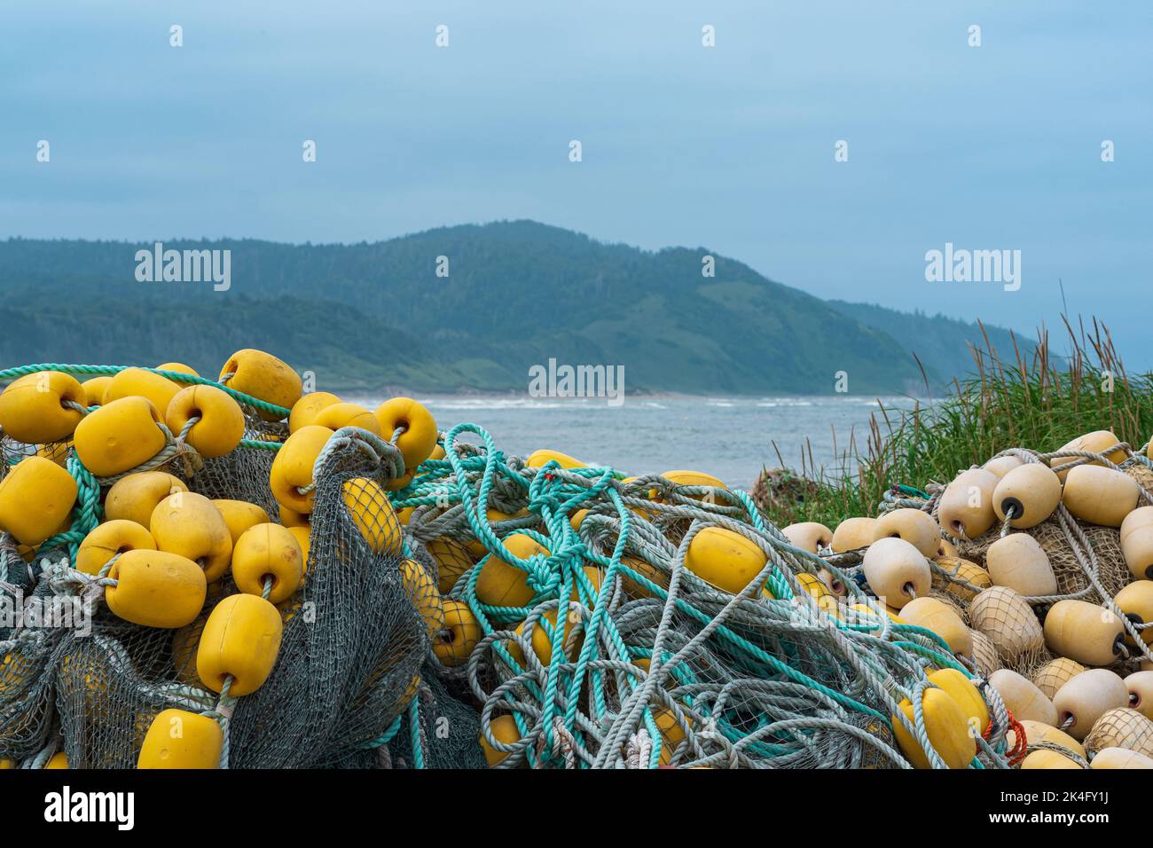 industrial fishing net with bright floats is folded on the seashore ...