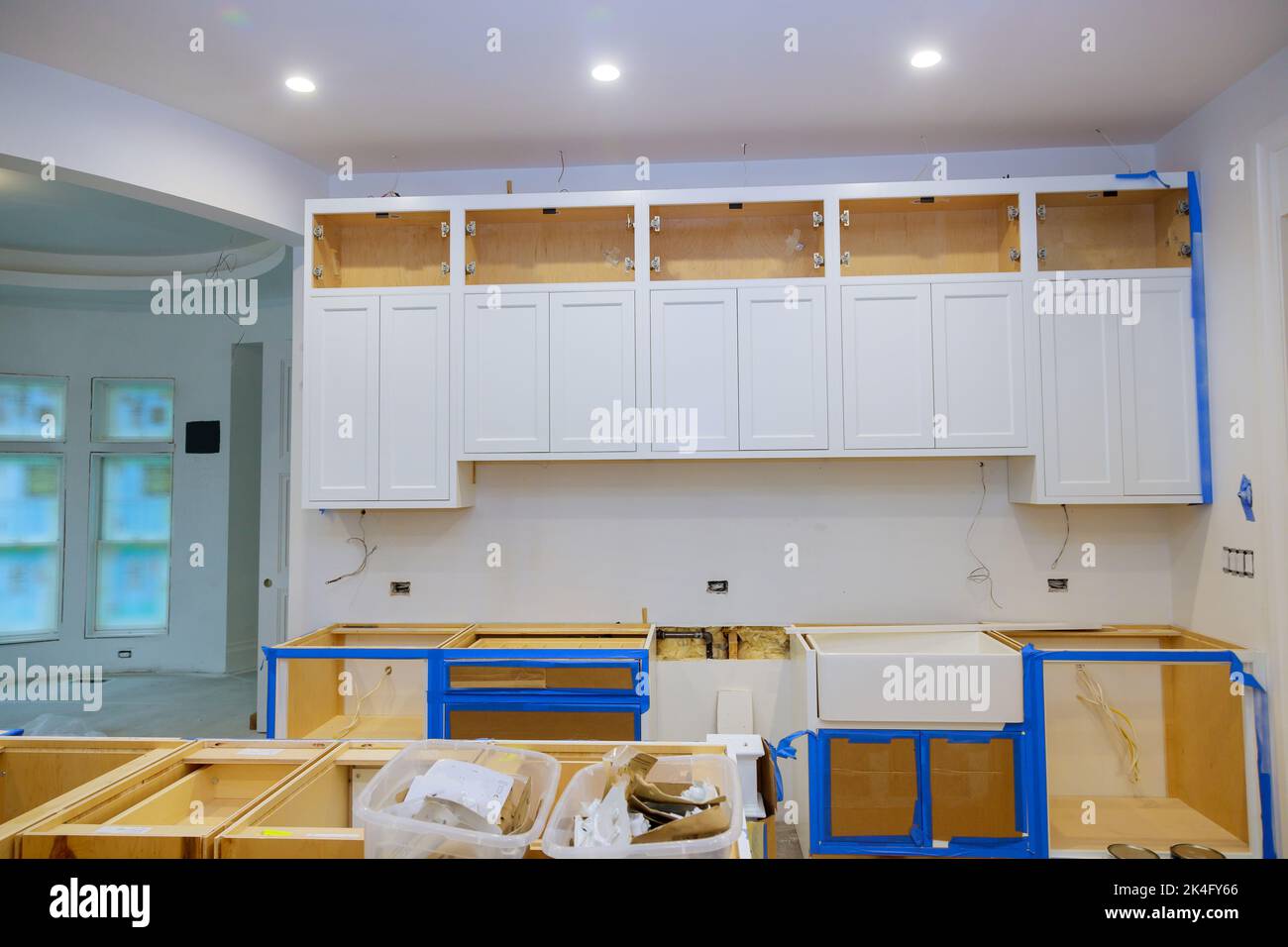 A white kitchen cabinet installation in a newly constructed house was ...