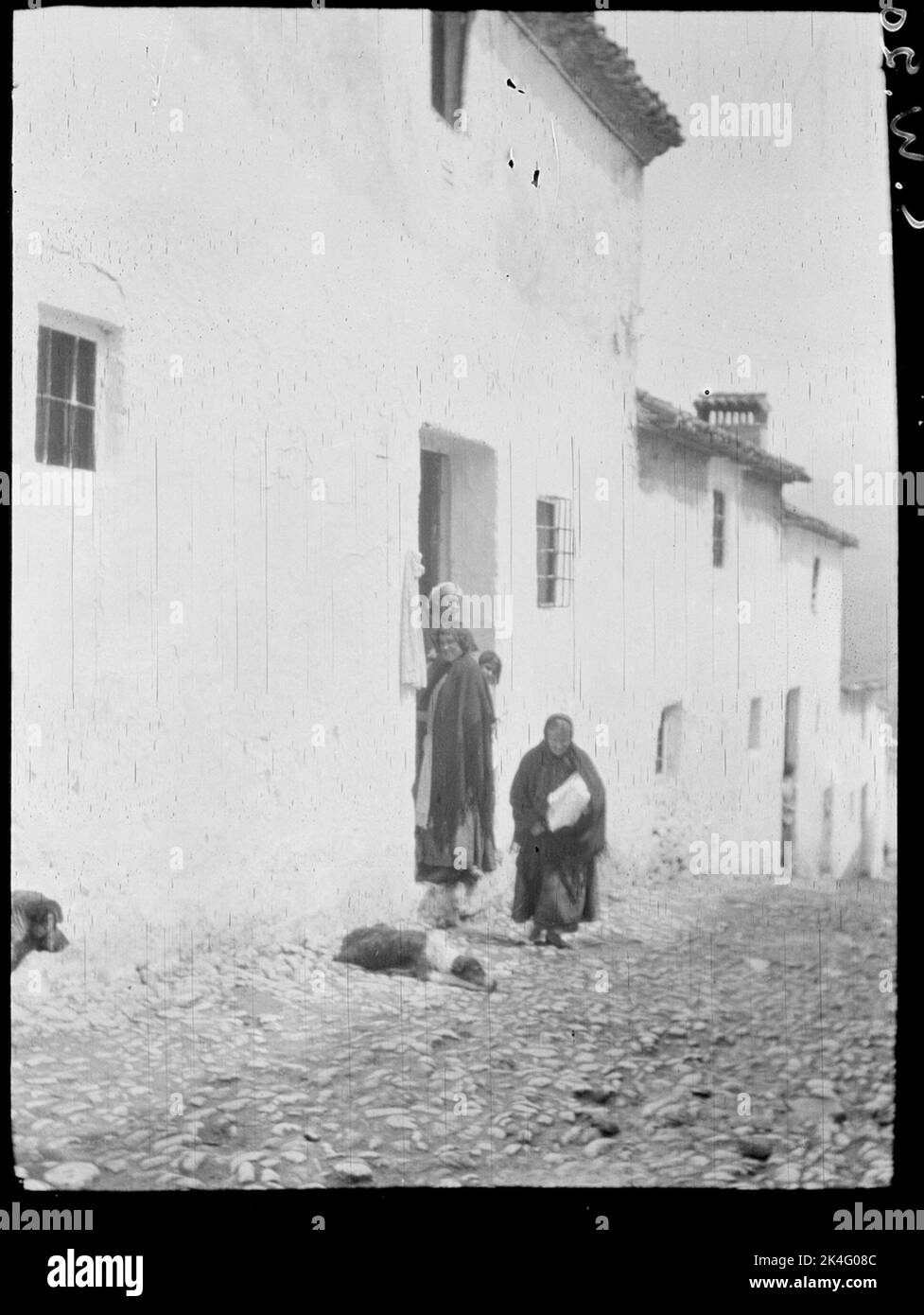 Women in the gate to a white -raised stone house. Probably Ronda, Spain ...