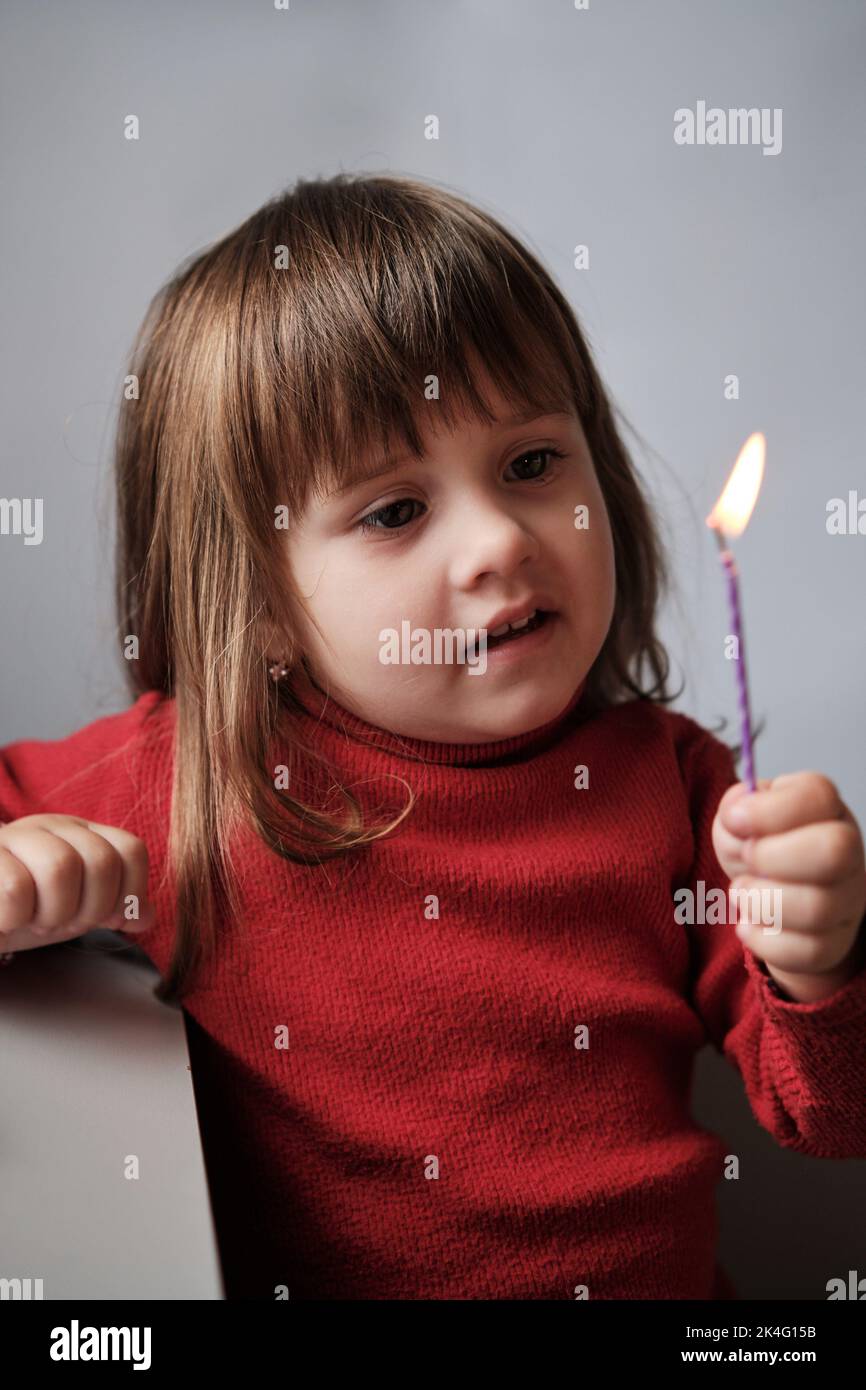 Adorable Little girl holding burning candle. Child holding candle ...