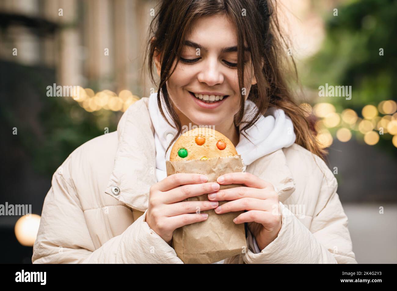 Attractive young woman with a beautiful gingerbread on a walk Stock ...