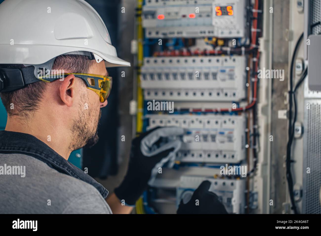 Man, an electrical technician working in a switchboard with fuses Stock ...