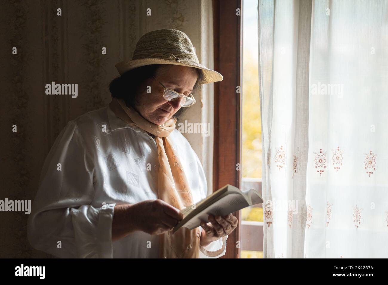 Woman reading a book at the window hi-res stock photography and images ...
