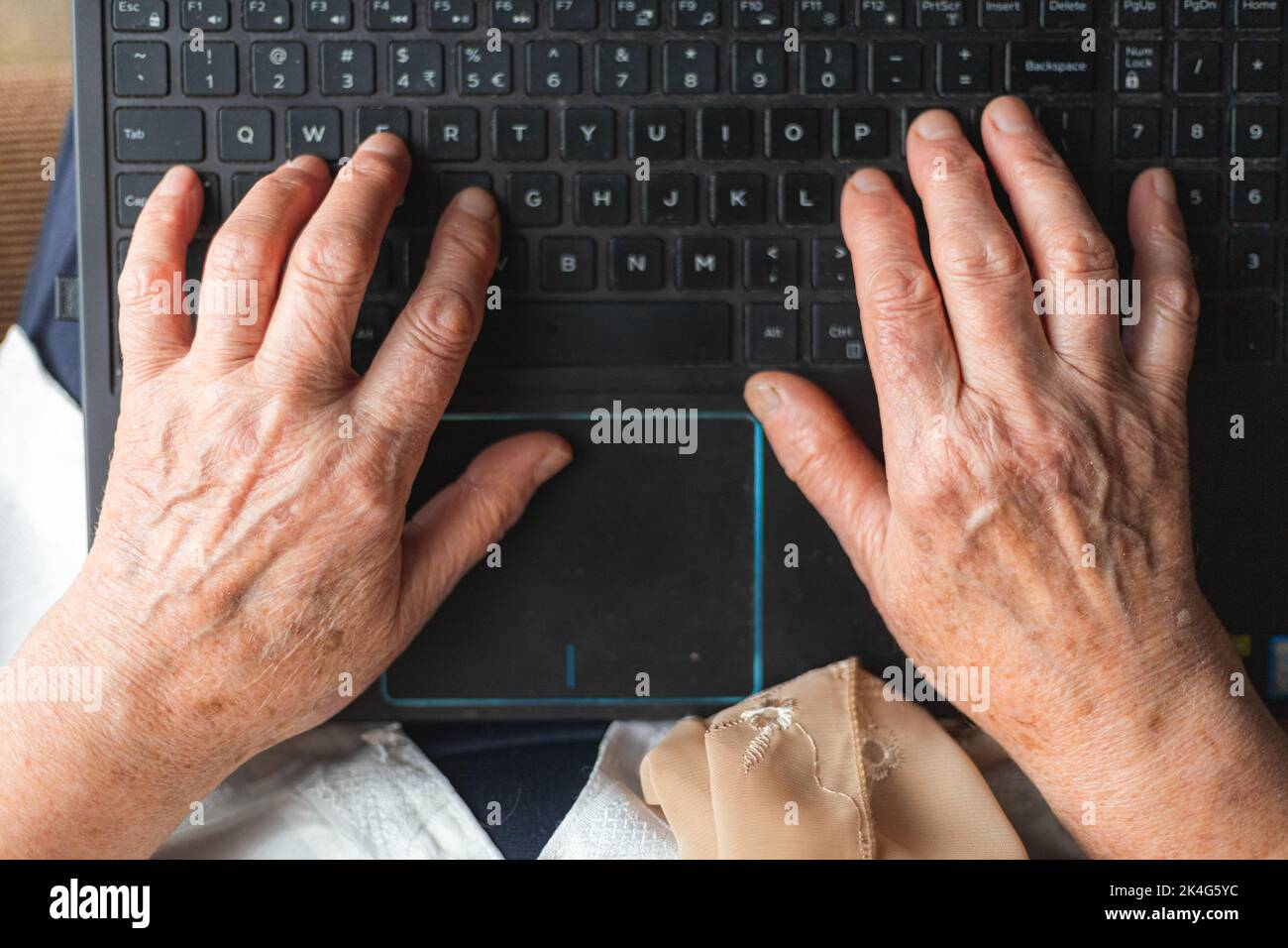 Elderly woman hands typing on the laptop keyboard. Top view Stock Photo ...