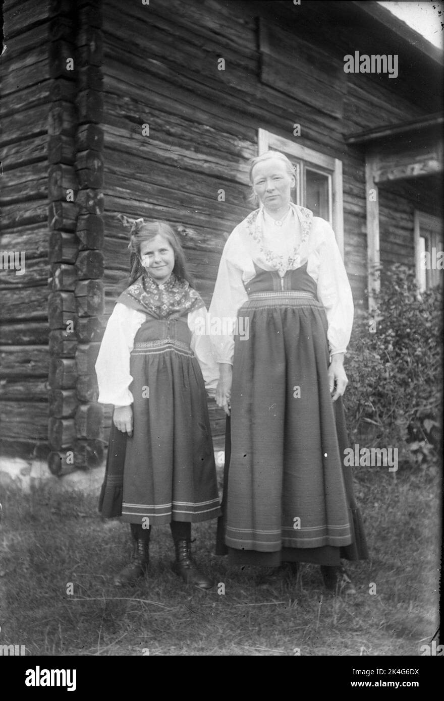 Full portrait of a woman and a girl in folk costumes in the yard. Lima ...