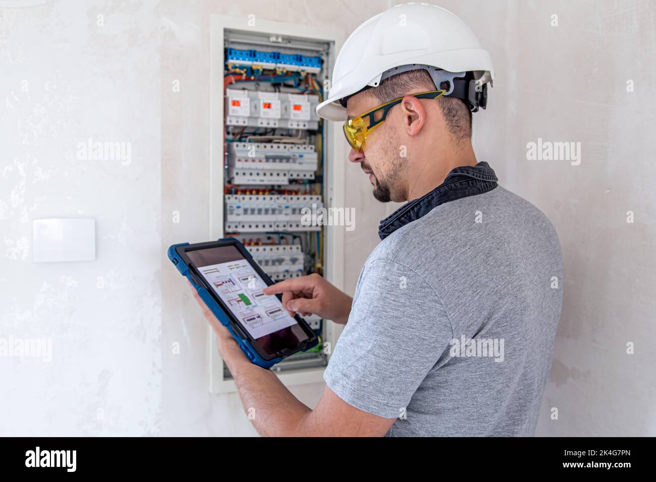 Electrical technician looking focused while working in a switchboard ...