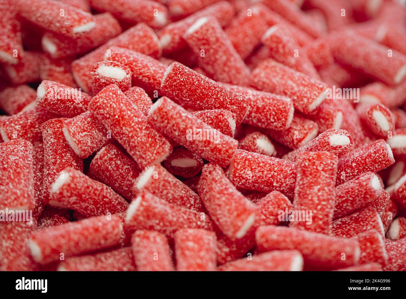 Red gummies jelly candies in sugar, background Stock Photo - Alamy