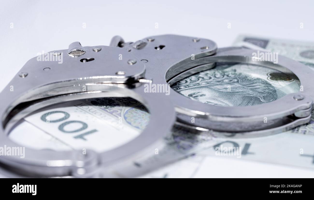 Police handcuffs and banknotes in Polish currency. The concept of ...