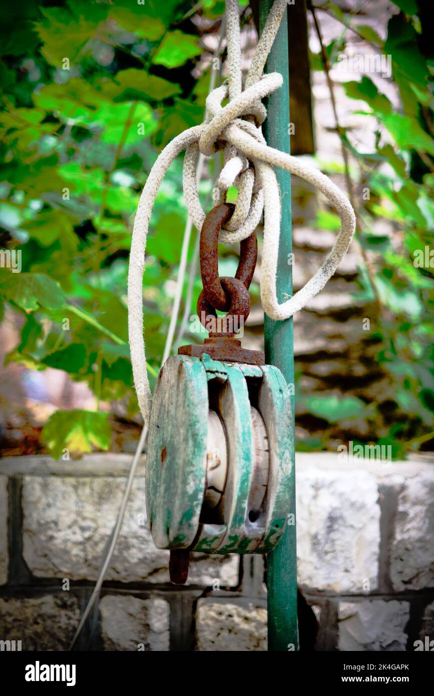 A vertical shot of a rusty pulley with a rope in a garden Stock Photo ...