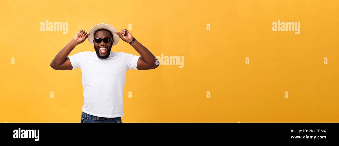 Close up portrait of a young man laughing with hands holding hat ...