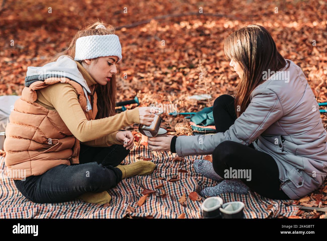 Two girls drinking hot tea from metal cups outdoor, camping Stock Photo ...