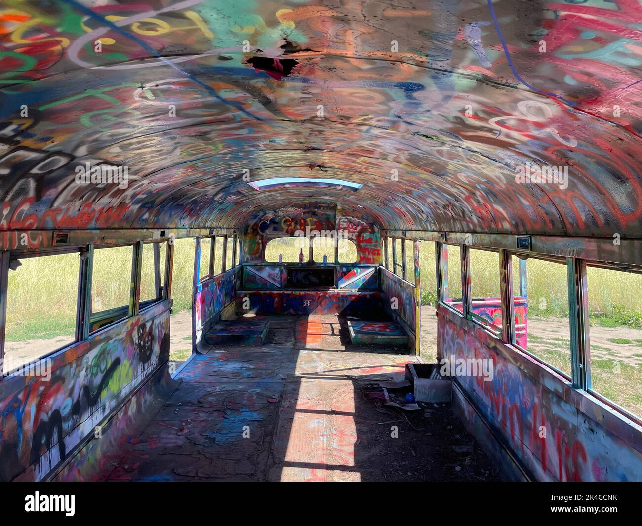 An abandoned old bus with colorful cool graffiti in a field during ...