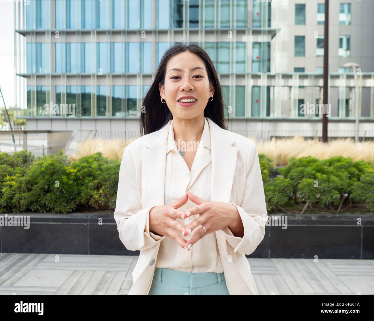 Asian young business woman looking at camera while making an ...