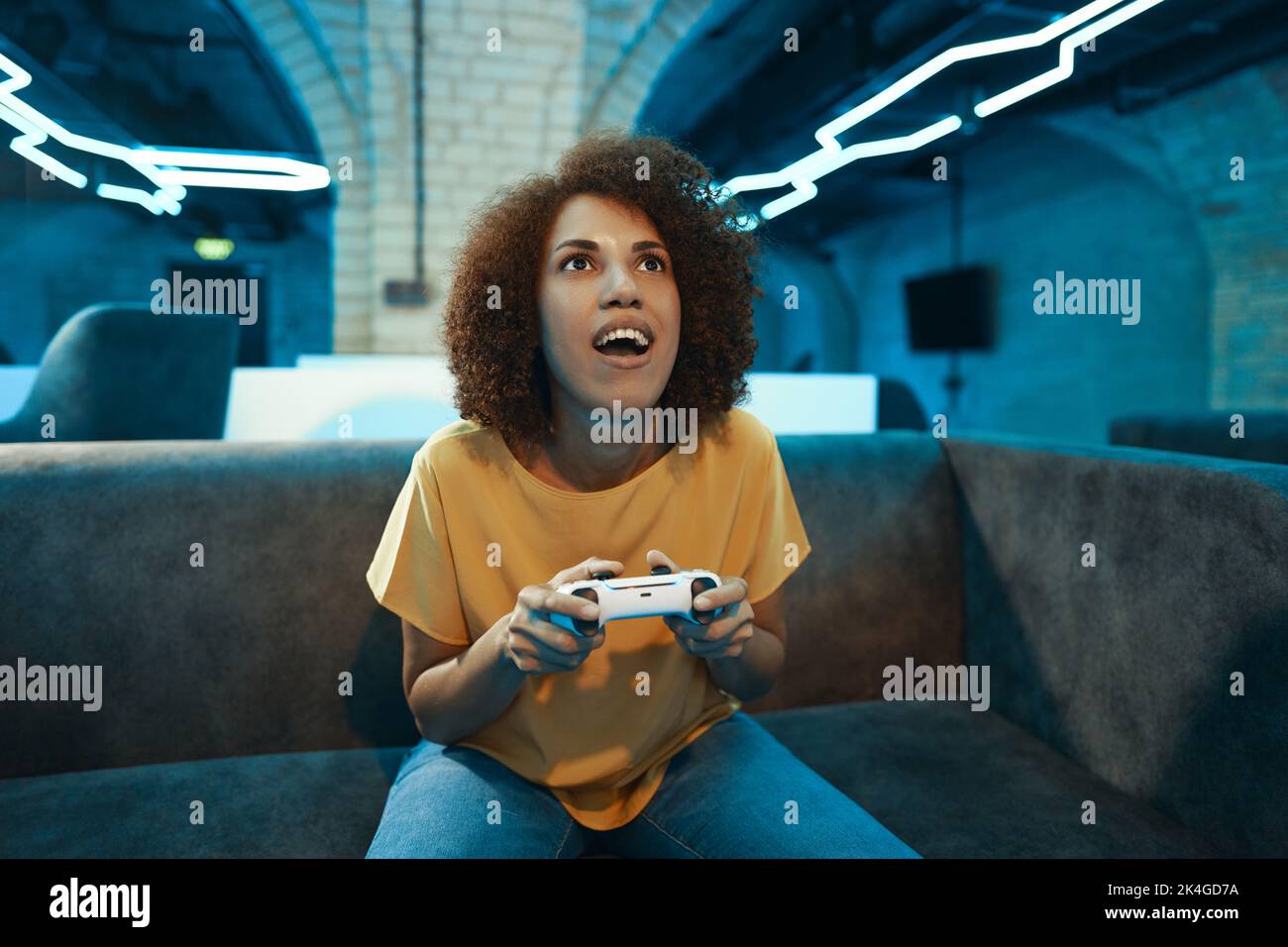 Young curly woman playing cyber games Stock Photo - Alamy