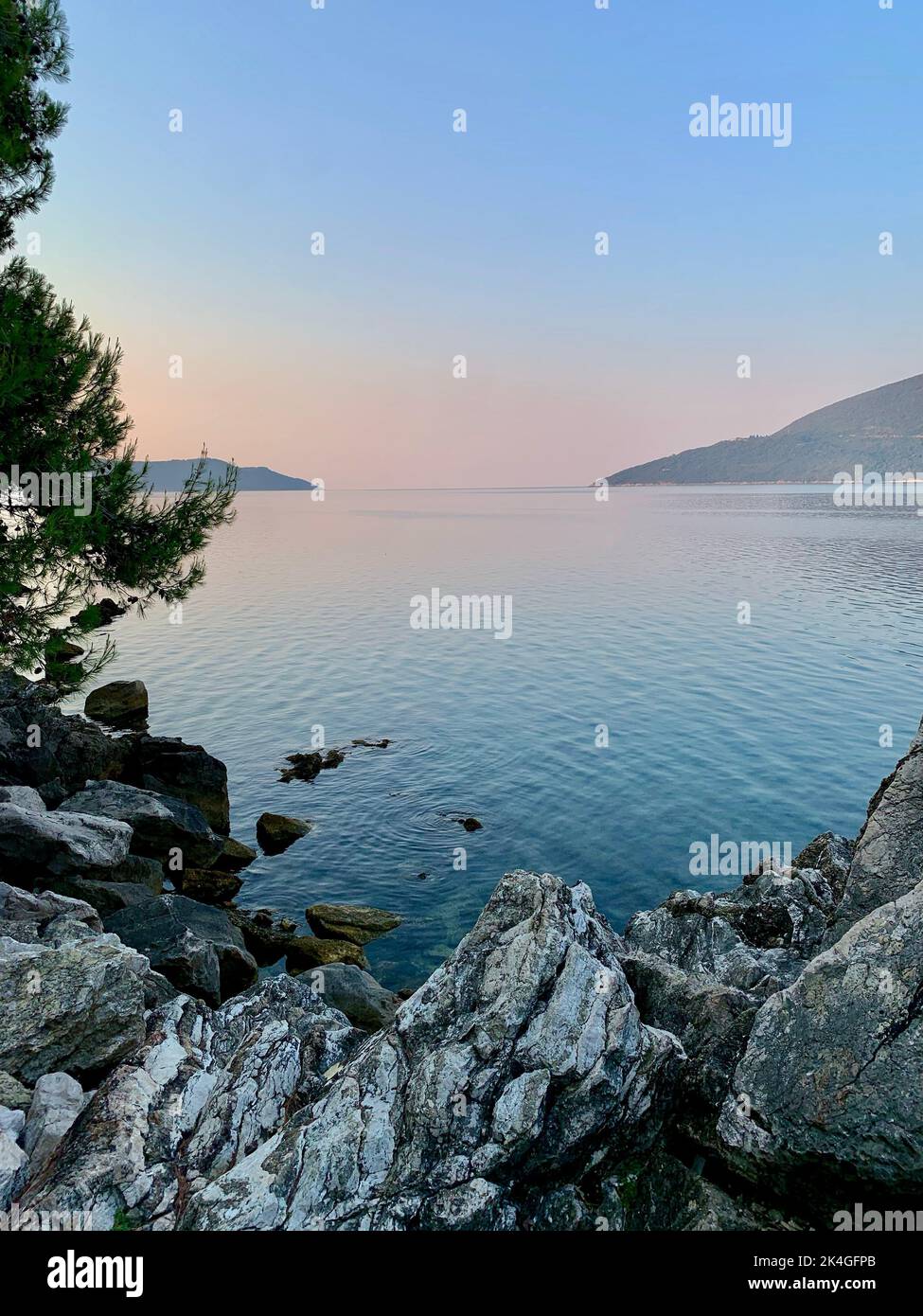 A beautiful shot of a sunset over a calm sea with blue clean water ...