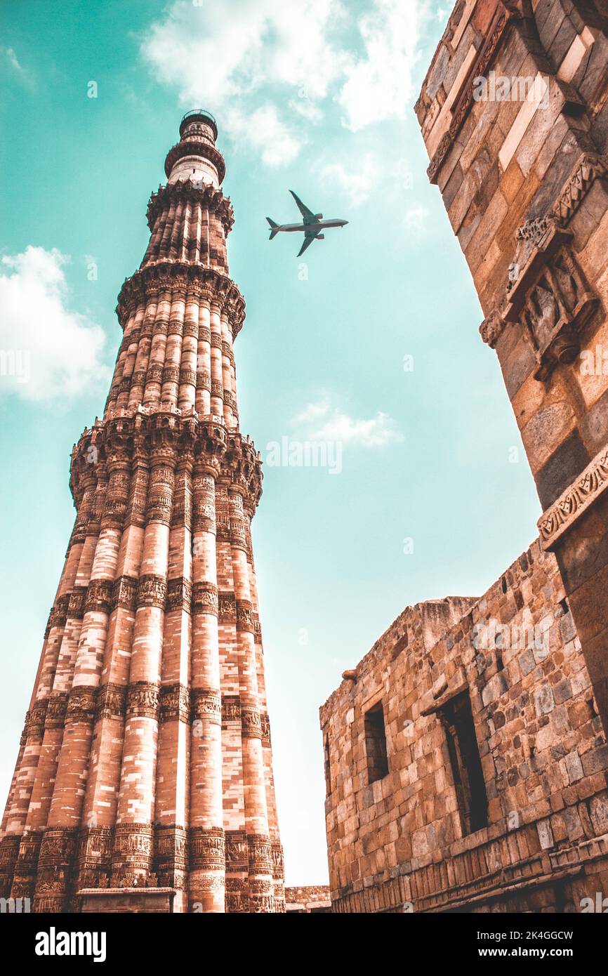 A vertical of the Iron Pillar monument and a plane in New Delhi, India ...