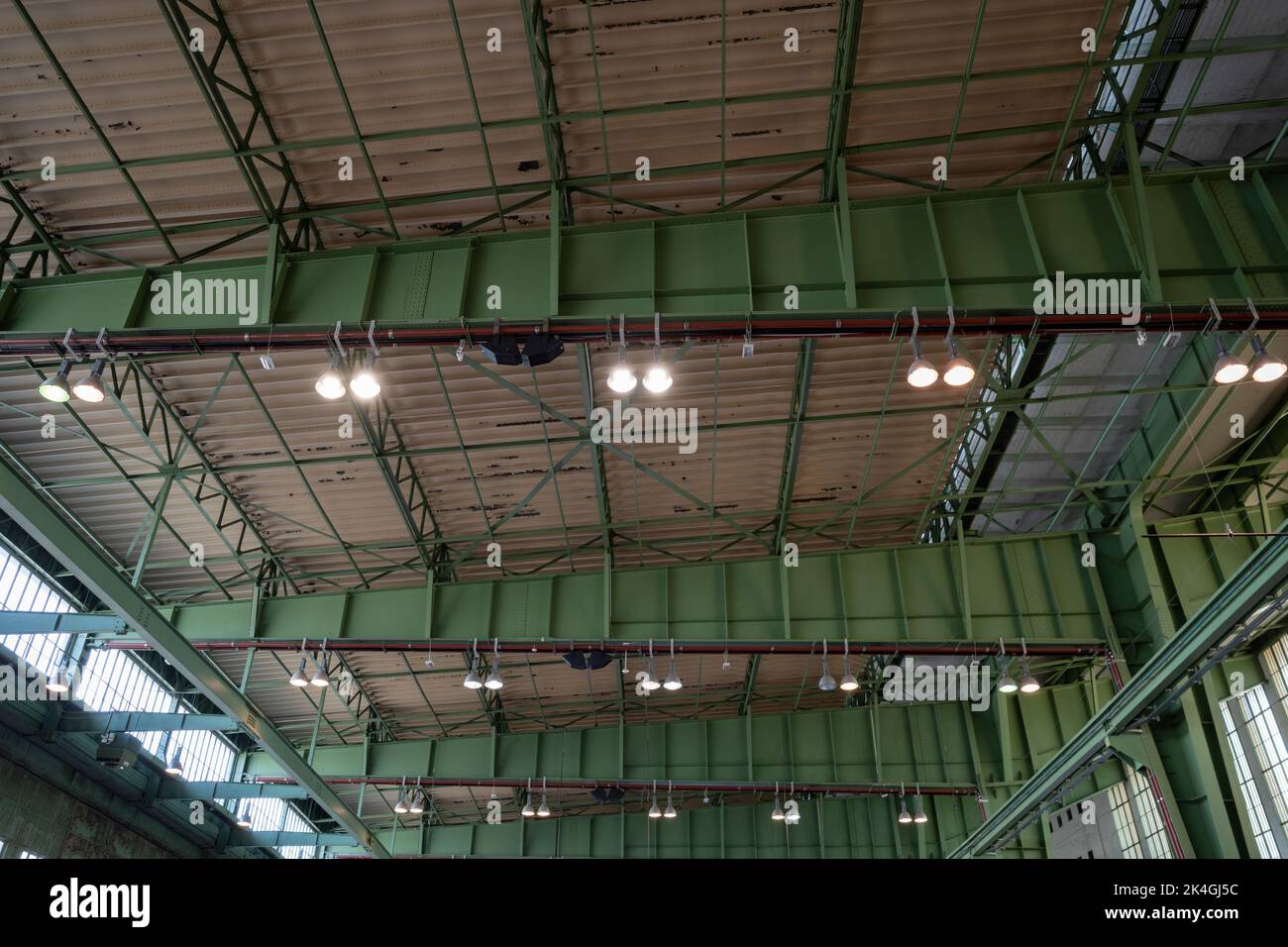 View under high ceiling of open interior space with huge steel truss ...