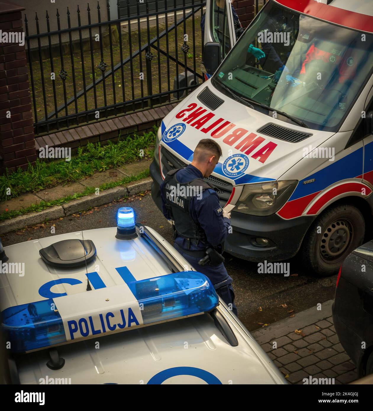 A European police in uniform using a cellphone on duty in front of ...