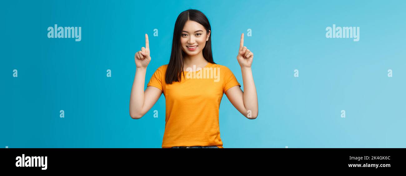 Cheerful cute young urban korean girl introduce new product, show promo ...