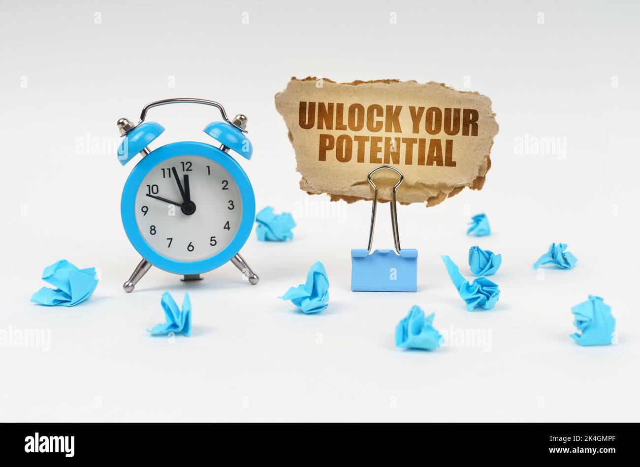 Time concept. On a white surface, an alarm clock, an office clip ...