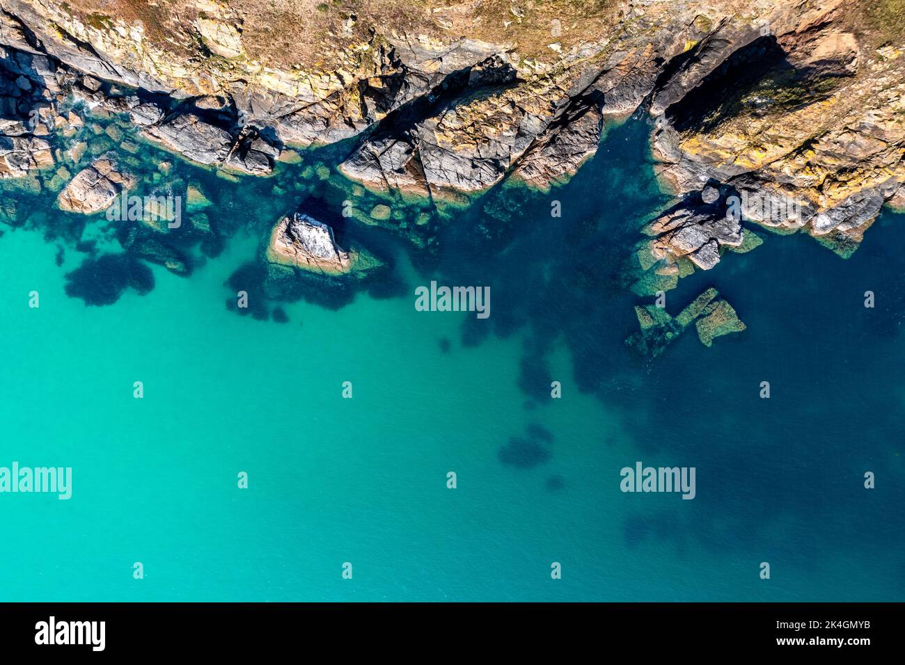 Aerial view directly above rugged rocky outcrop of land jutting into a ...