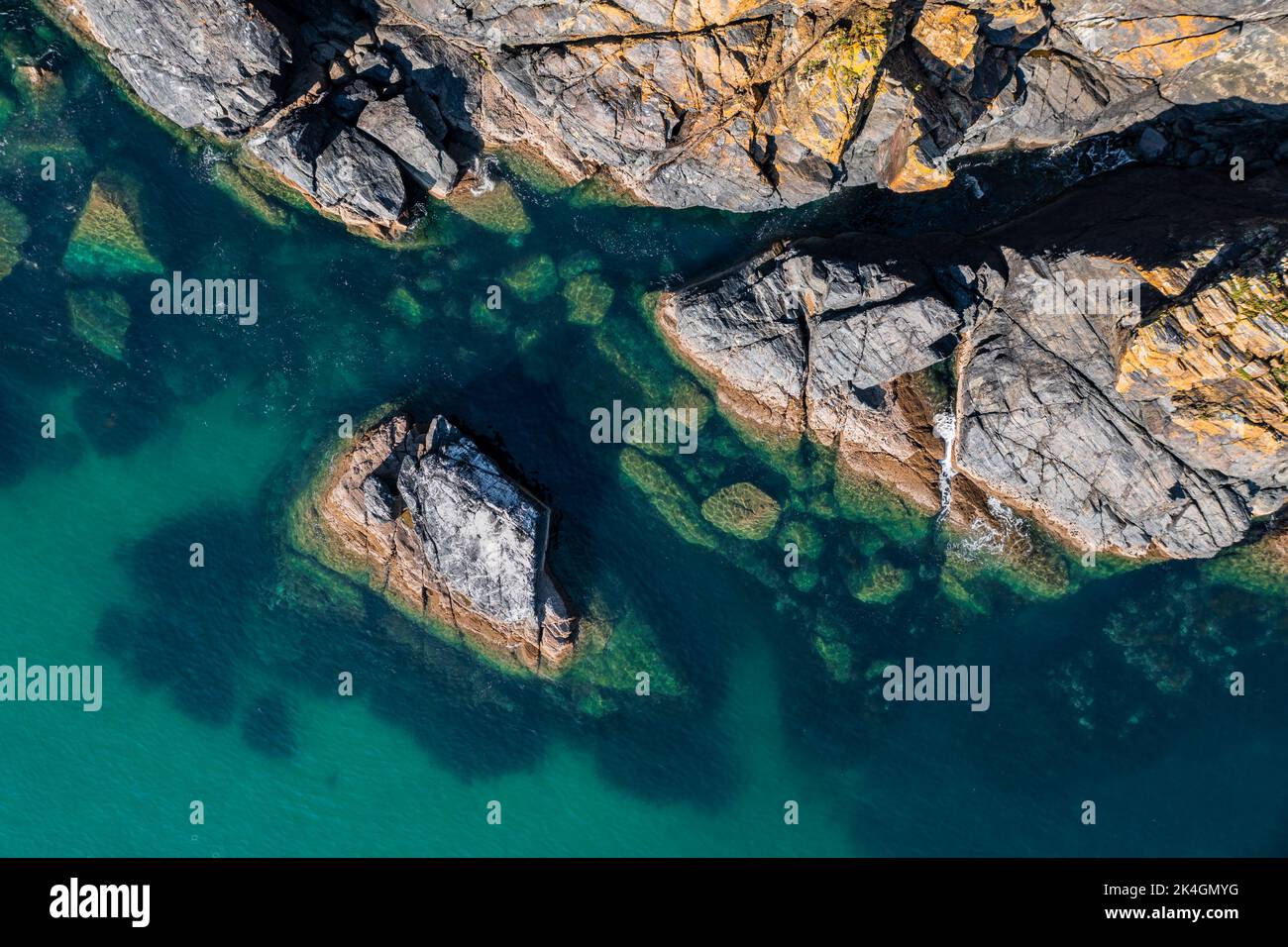 Aerial view directly above rugged rocky outcrop of land jutting into a ...