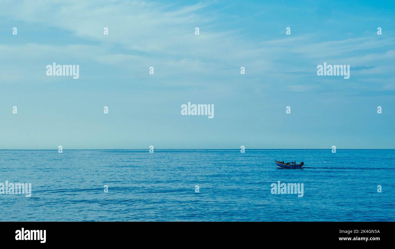 Simple background Calm dark blue sea fishing boat alone white pale ...
