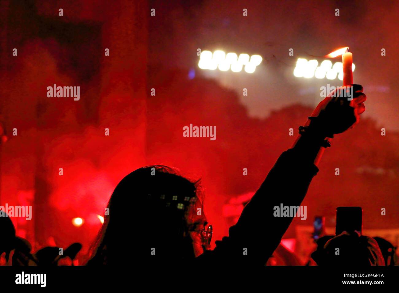 A soccer fan holds a lit candle in memory of the football riot ...