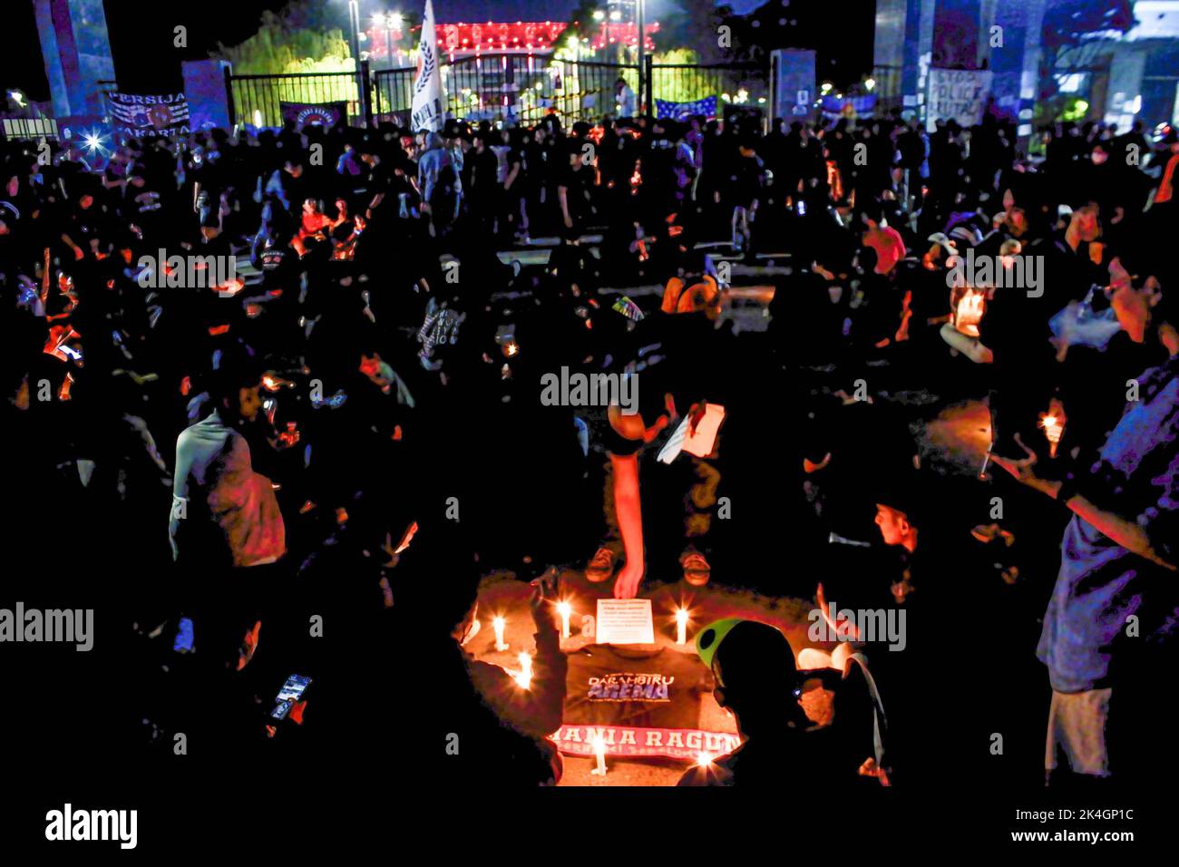 Indonesian football fans light candles in memory of the football riot ...
