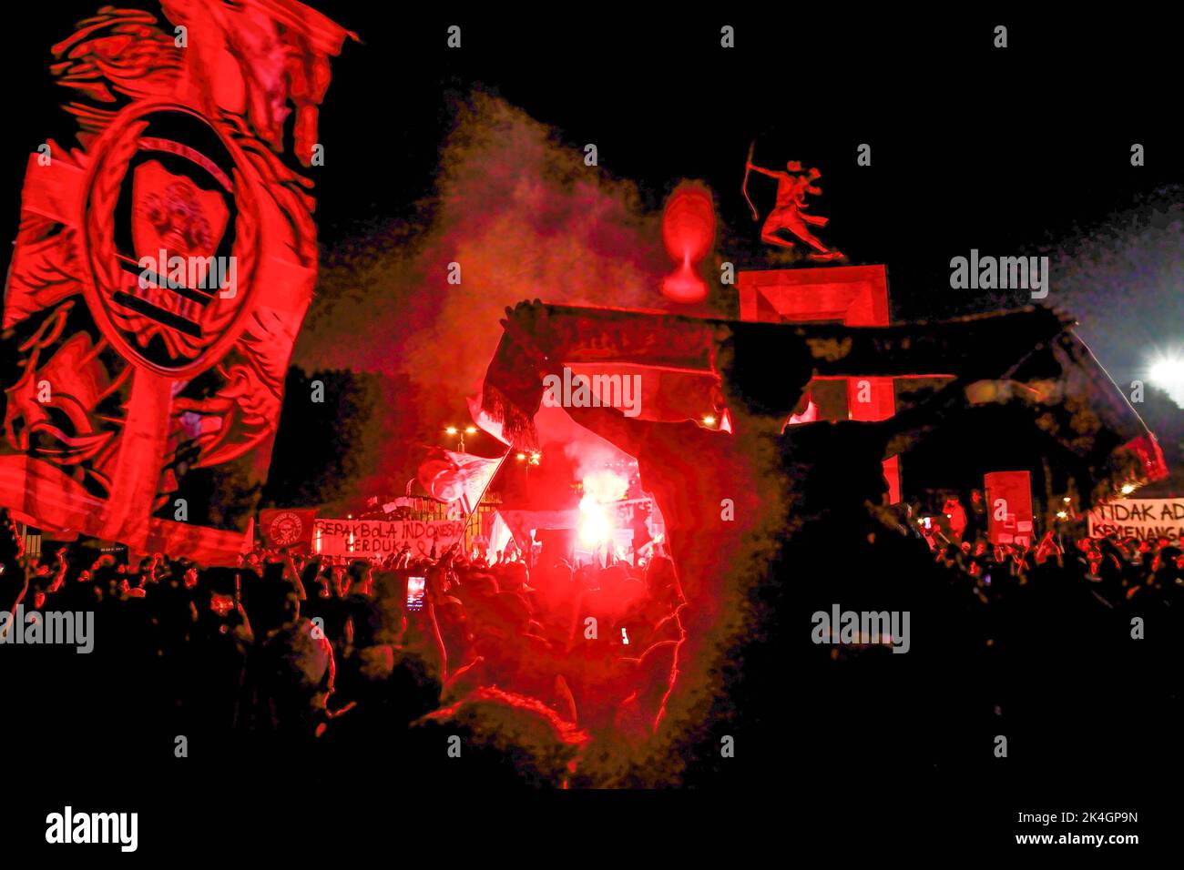 Soccer fans light flares in memory of the football riot. Indonesian ...
