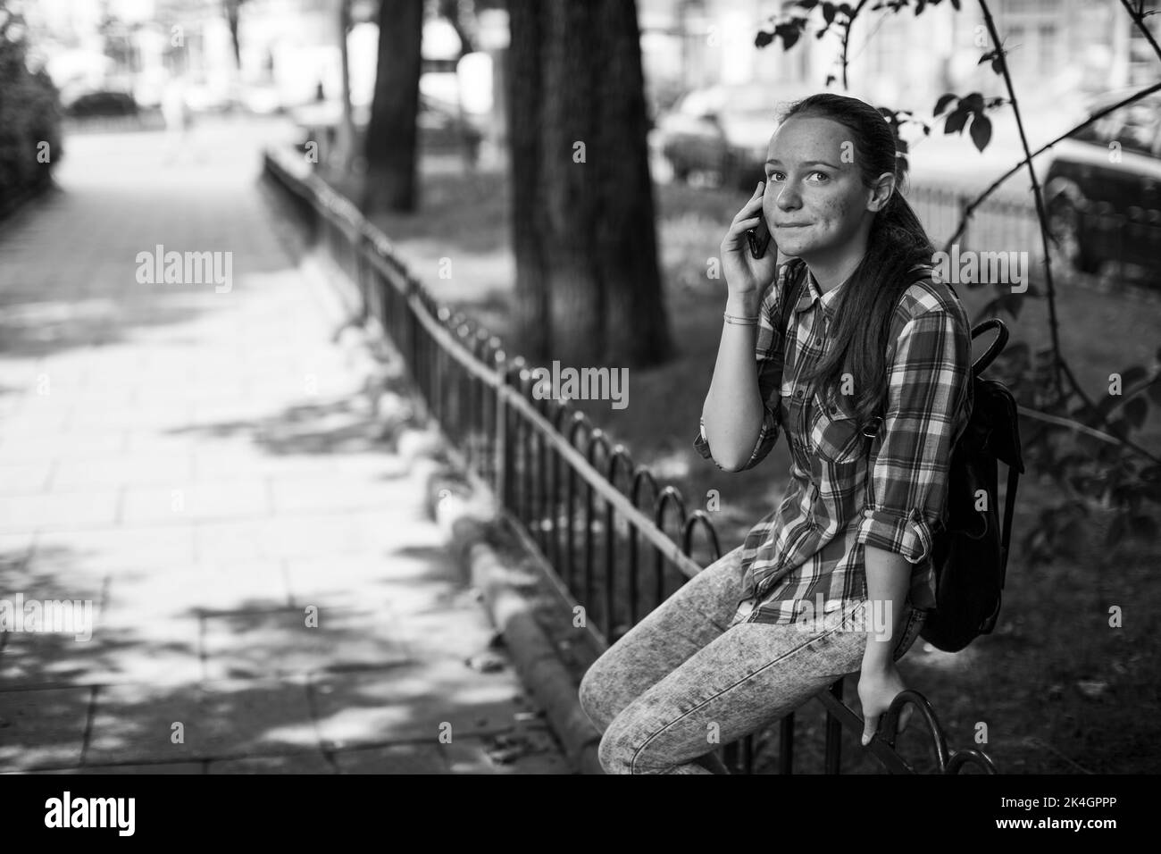 A teengirl talking on smartphone in a Park. Black and white photo Stock ...