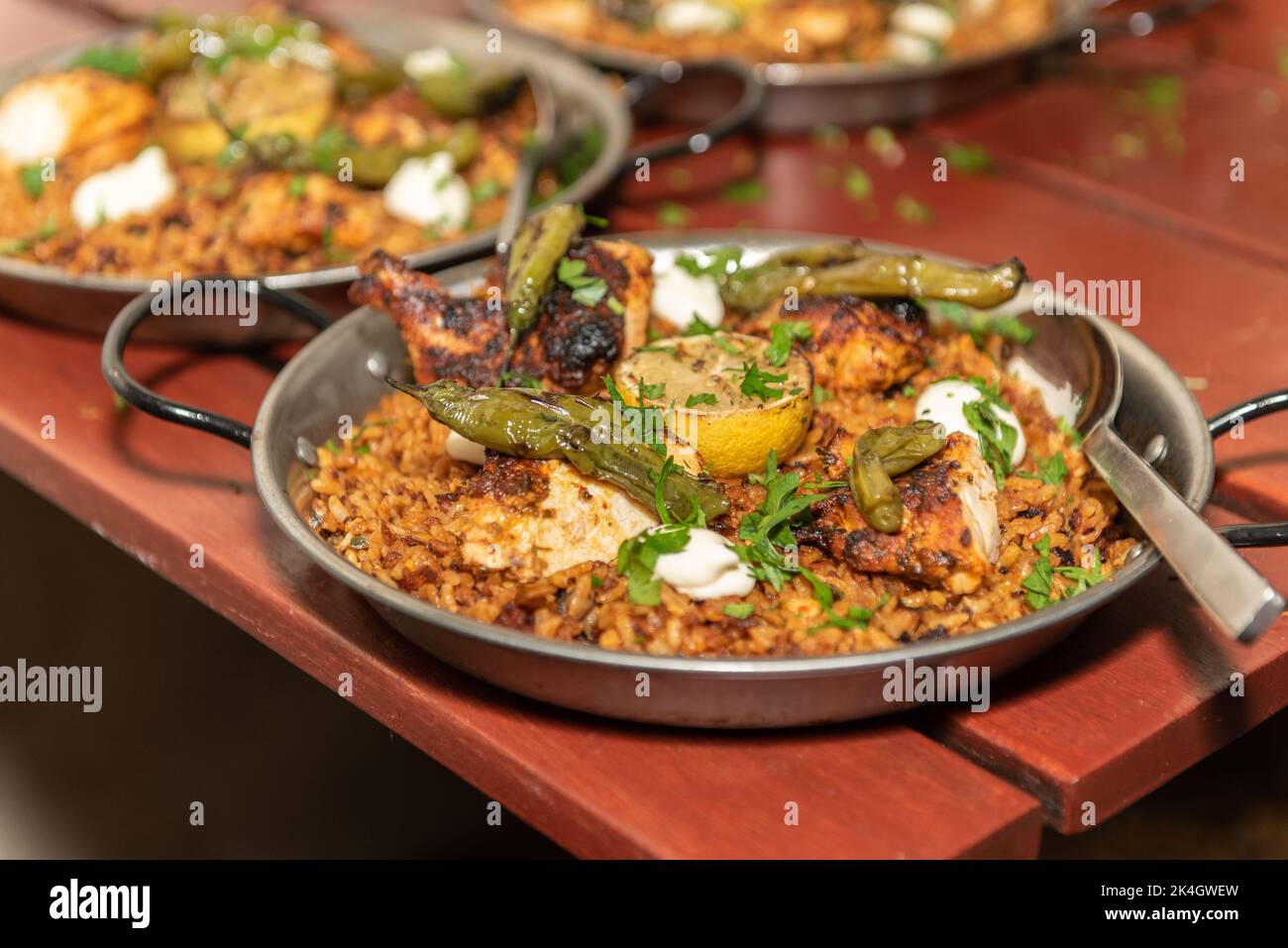 Table full of paella plates with this one featuring rice chicken, lemon ...