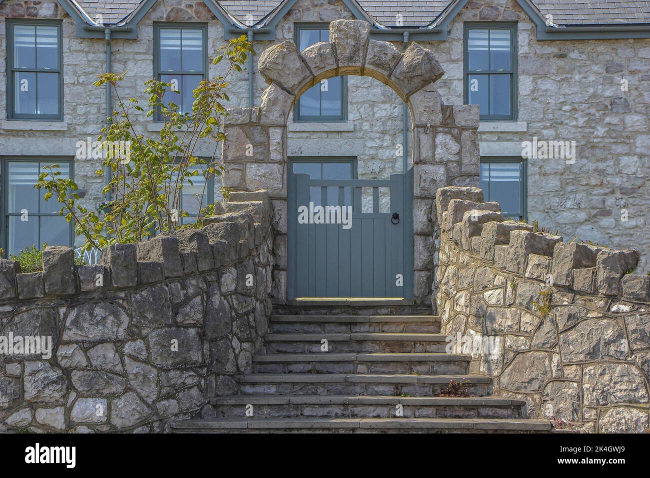 steps leading upwards to anarched gate which is painted blue and is in ...