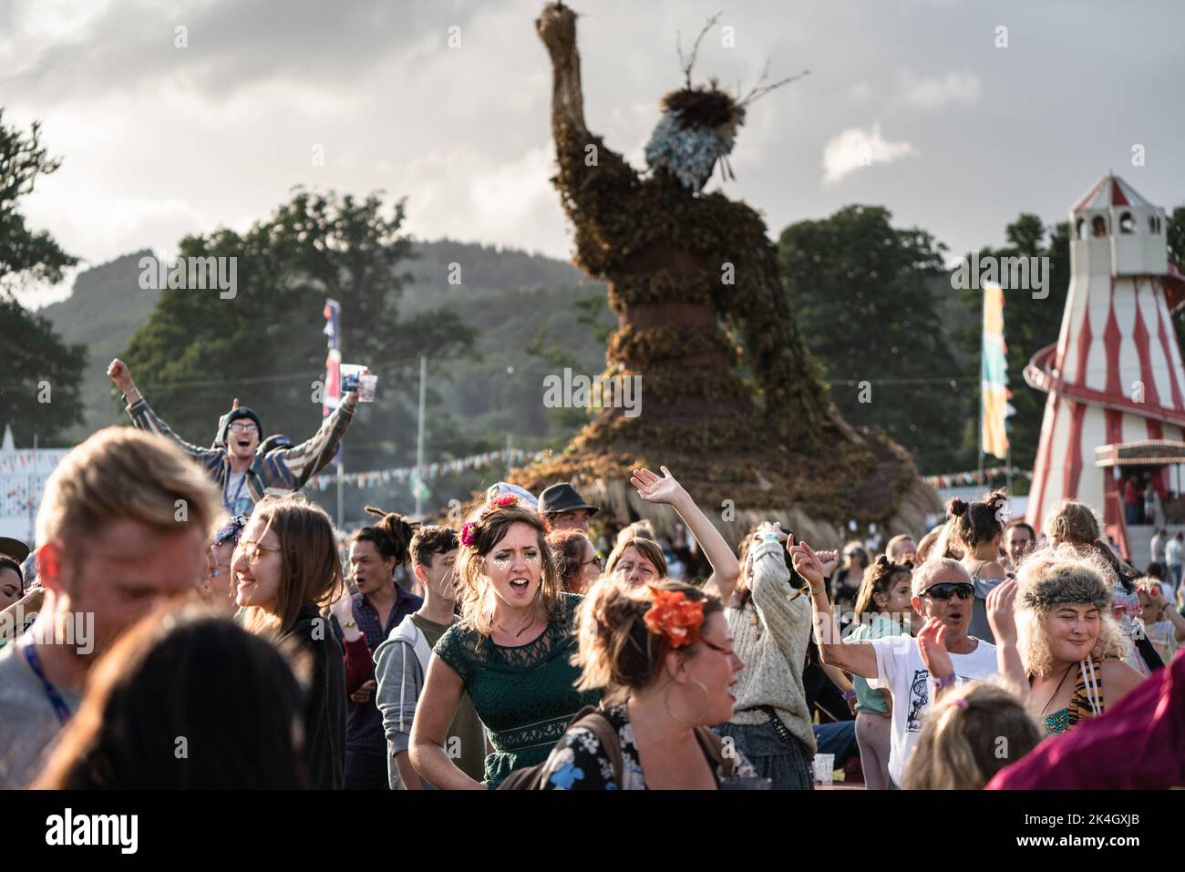 A crazy crowd dances under the giant Wicker man at sunset at the Green ...